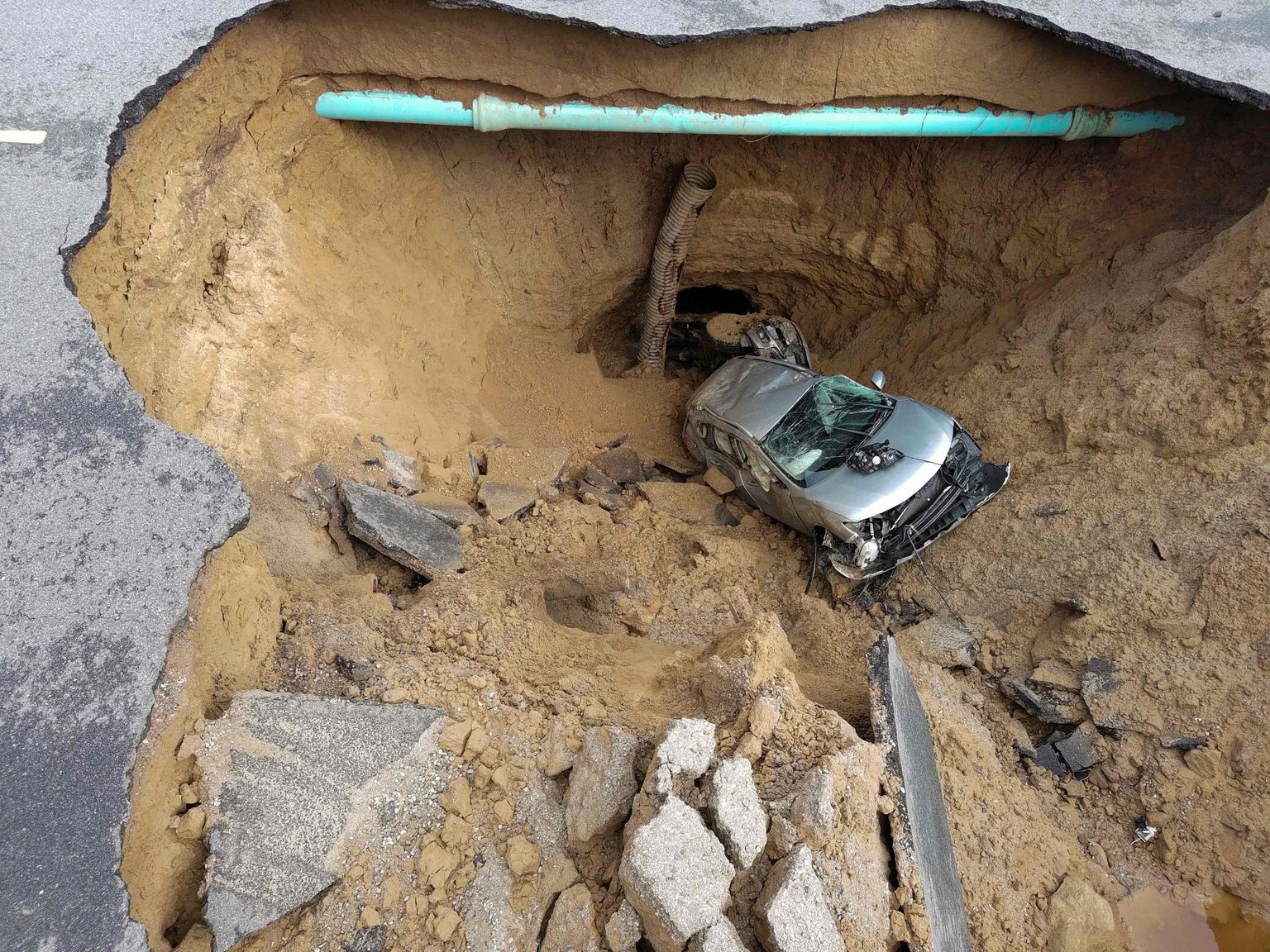 FOTO ASV pamatīgs zemes iegruvums "aprij" vairākus auto